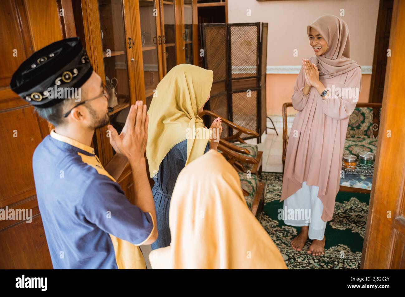muslim woman welcoming guest's at home on eid mubarak Stock Photo - Alamy