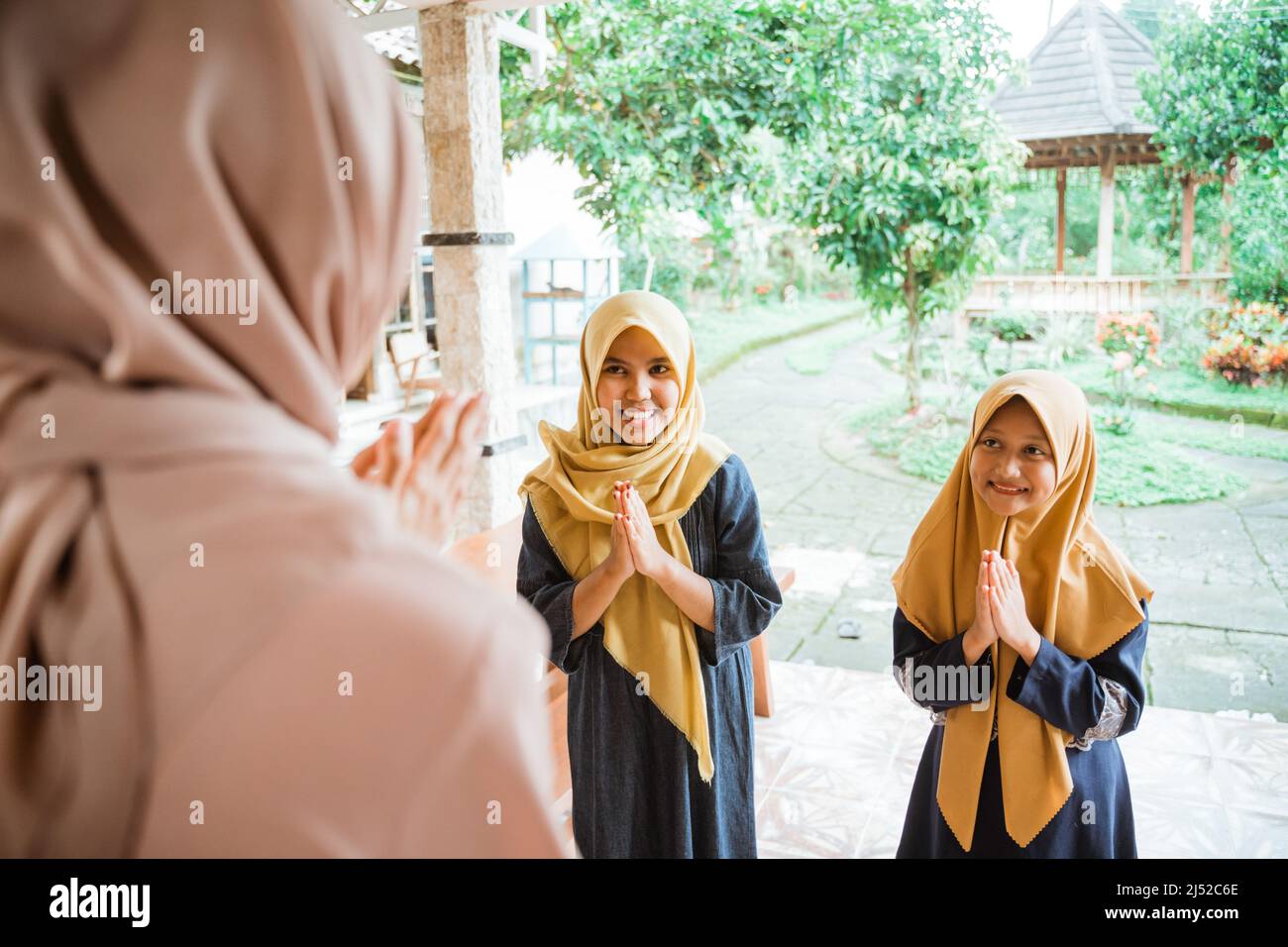 muslim woman welcoming guest's at home on eid mubarak Stock Photo - Alamy