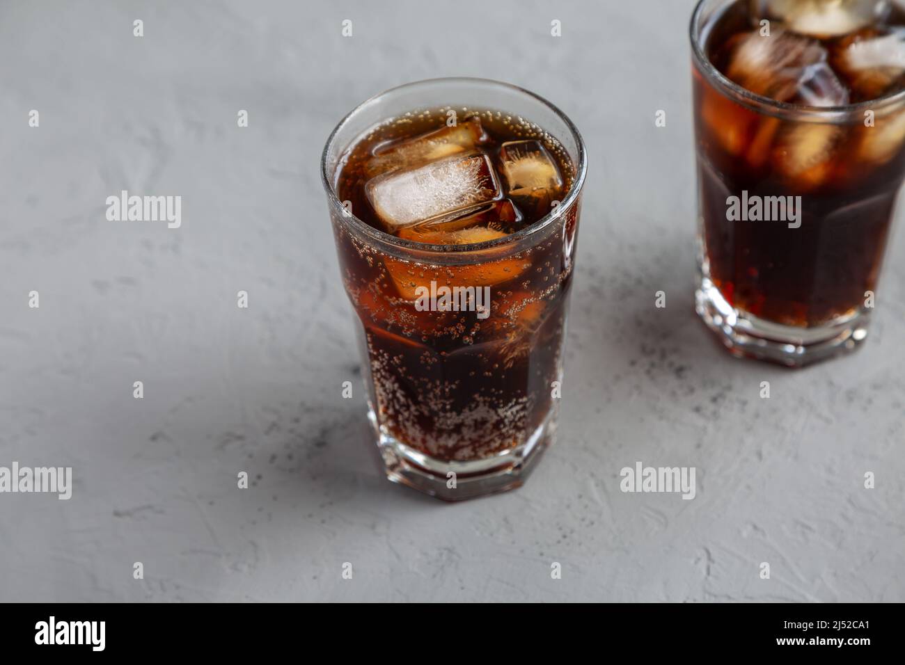 Cold Refreshing Dark Cola with Ice Cubes on a gray background, side view Stock Photo - Alamy
