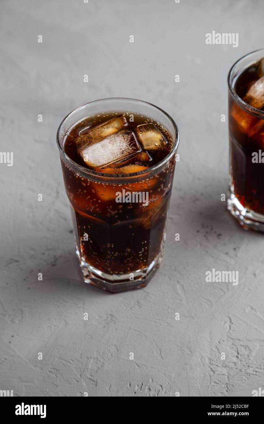 Cold Refreshing Dark Cola with Ice Cubes on a gray background, side view Stock Photo - Alamy