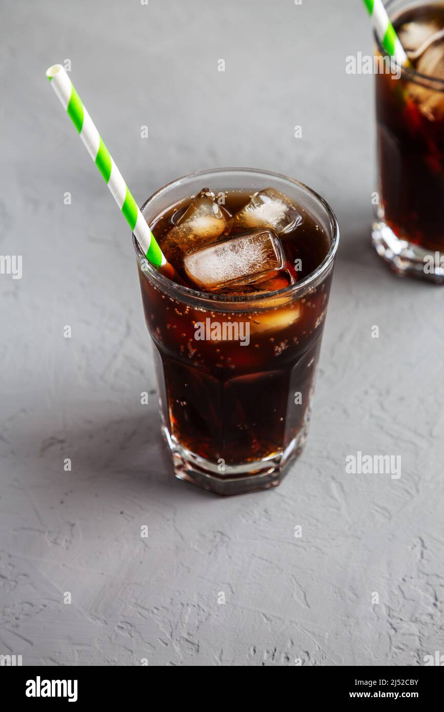 Cold Refreshing Dark Cola with Ice Cubes on a gray background, side view Stock Photo - Alamy
