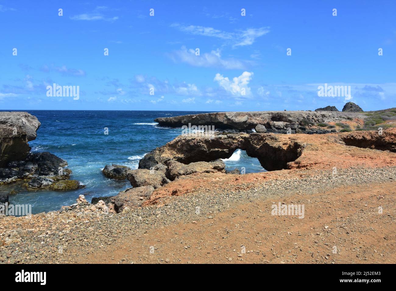 Rural rugged coastline with a natural bridge on black sand beach in ...