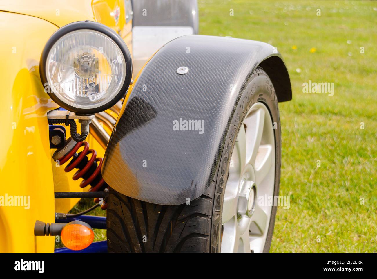 Headlight and front wheel of a yellow Caterham Seven Roadsport Stock ...