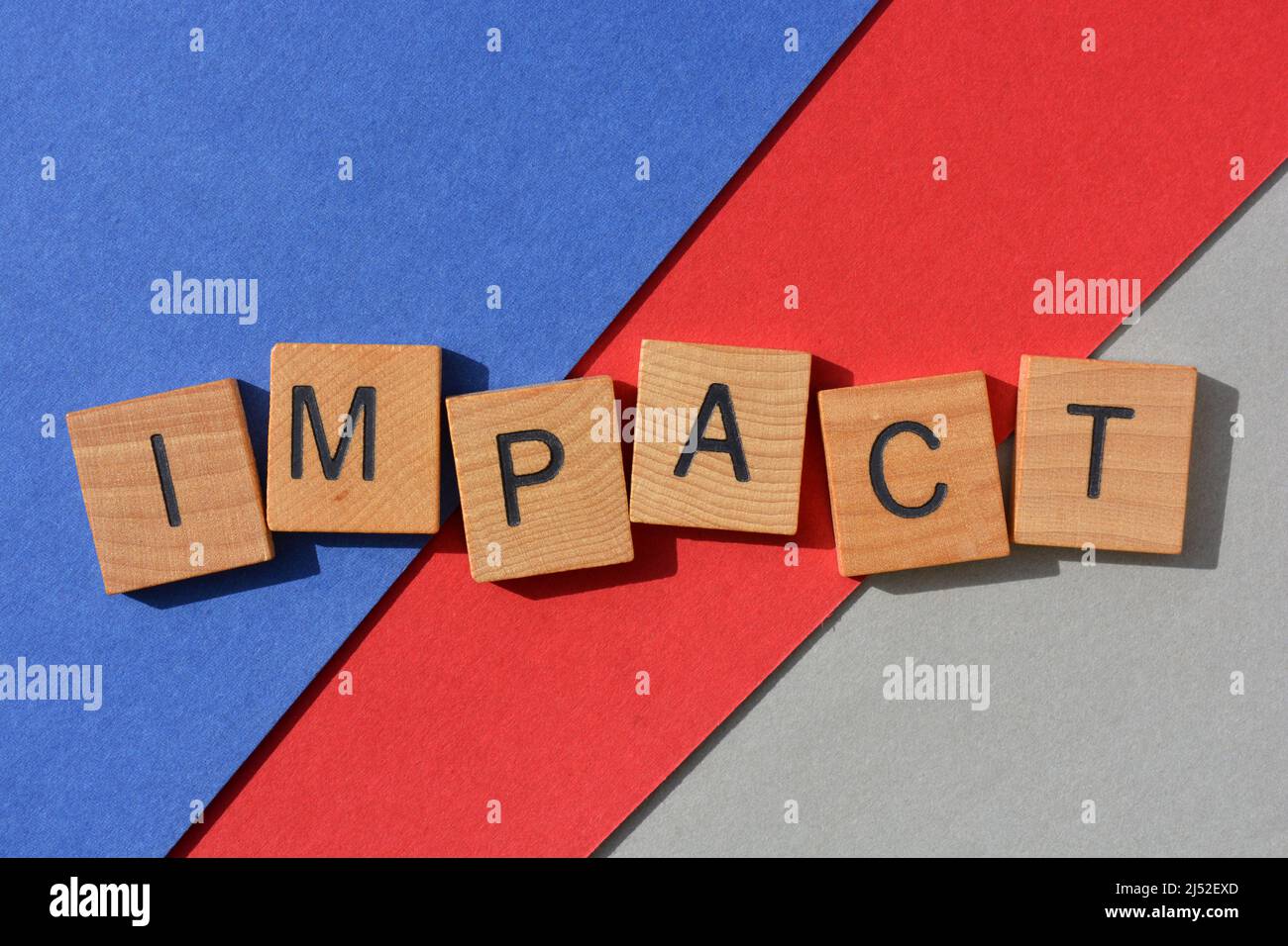 Impact, word in wooden alphabet letters isolated on multicolour ...