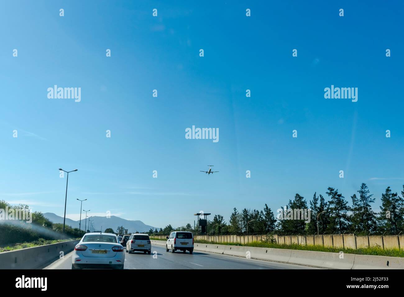 Airplane flying above Blida highway on Boufarik military airport ...