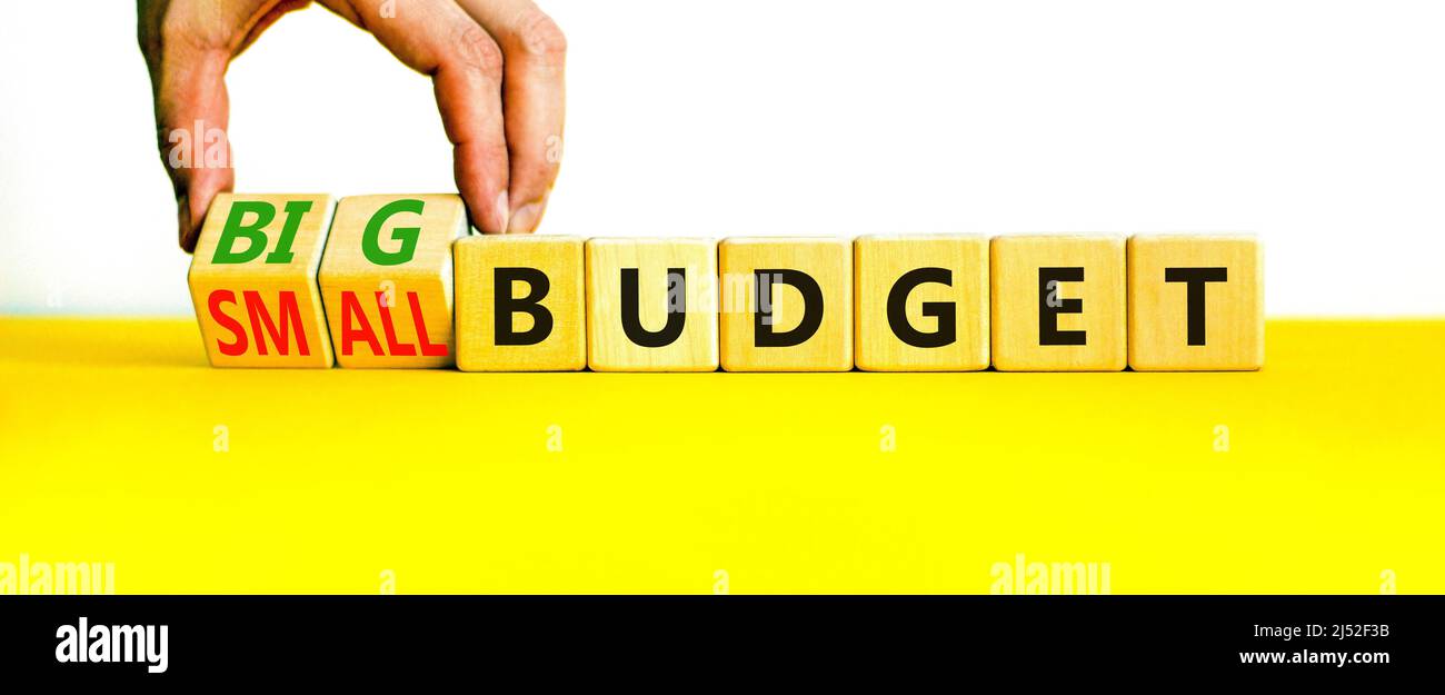 Big or small budget symbol. Businessman turns wooden cubes and changes ...