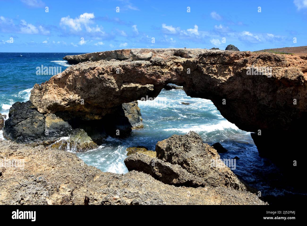 Natural lava rock bridge on the black sand beach in Aruba Stock Photo ...