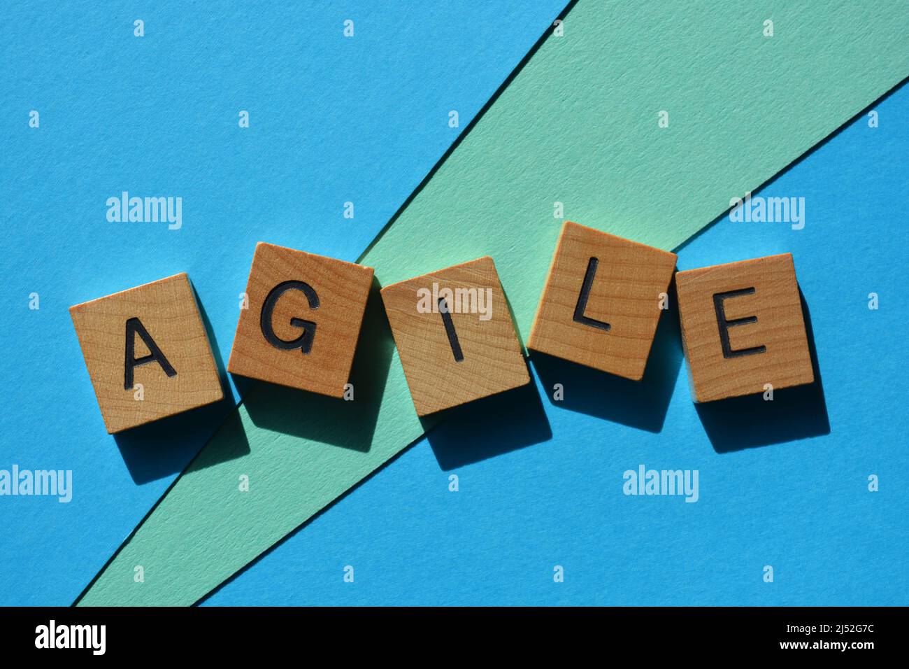 Agile, word in wooden alphabet letters isolated on blue background ...
