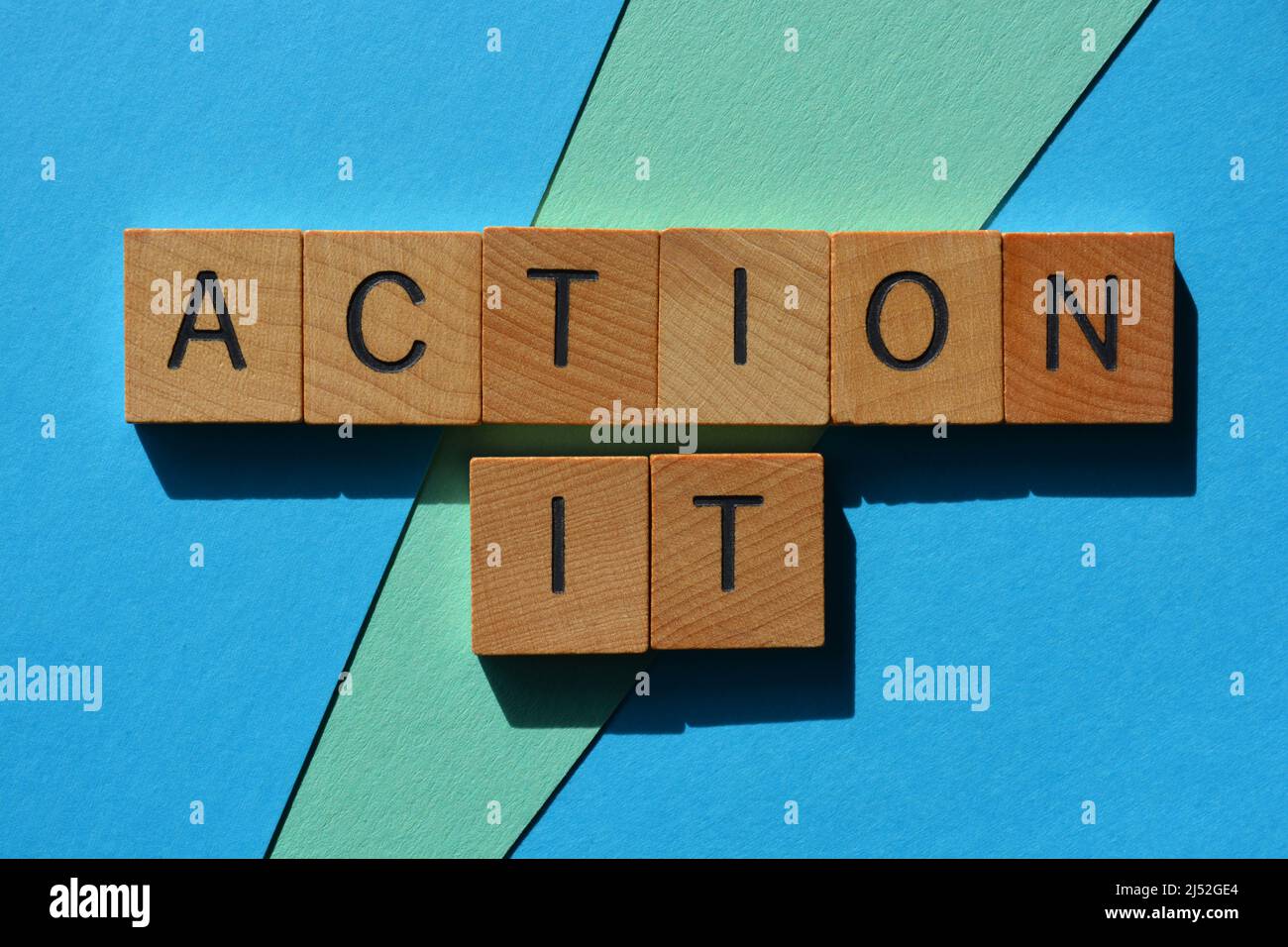 Action It, words in wooden alphabet letters isolated on blue background ...