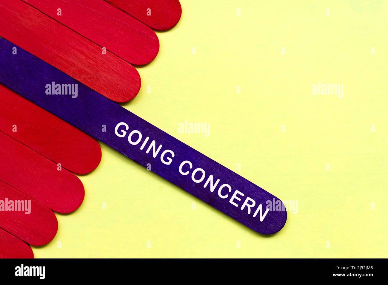Going concern text on purple color wooden stick. Business and ...