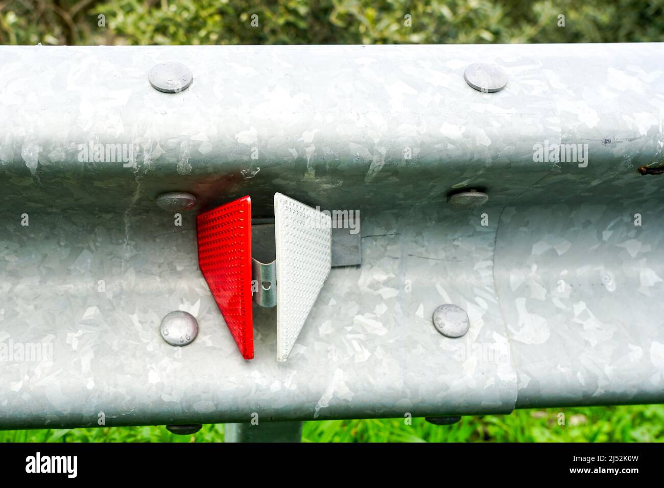 closeup of a profiled metal roadside barrier with a red and white ...