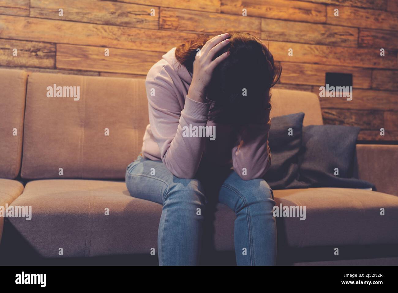 Unhappy sad young woman touching head, thinking about problems or ...