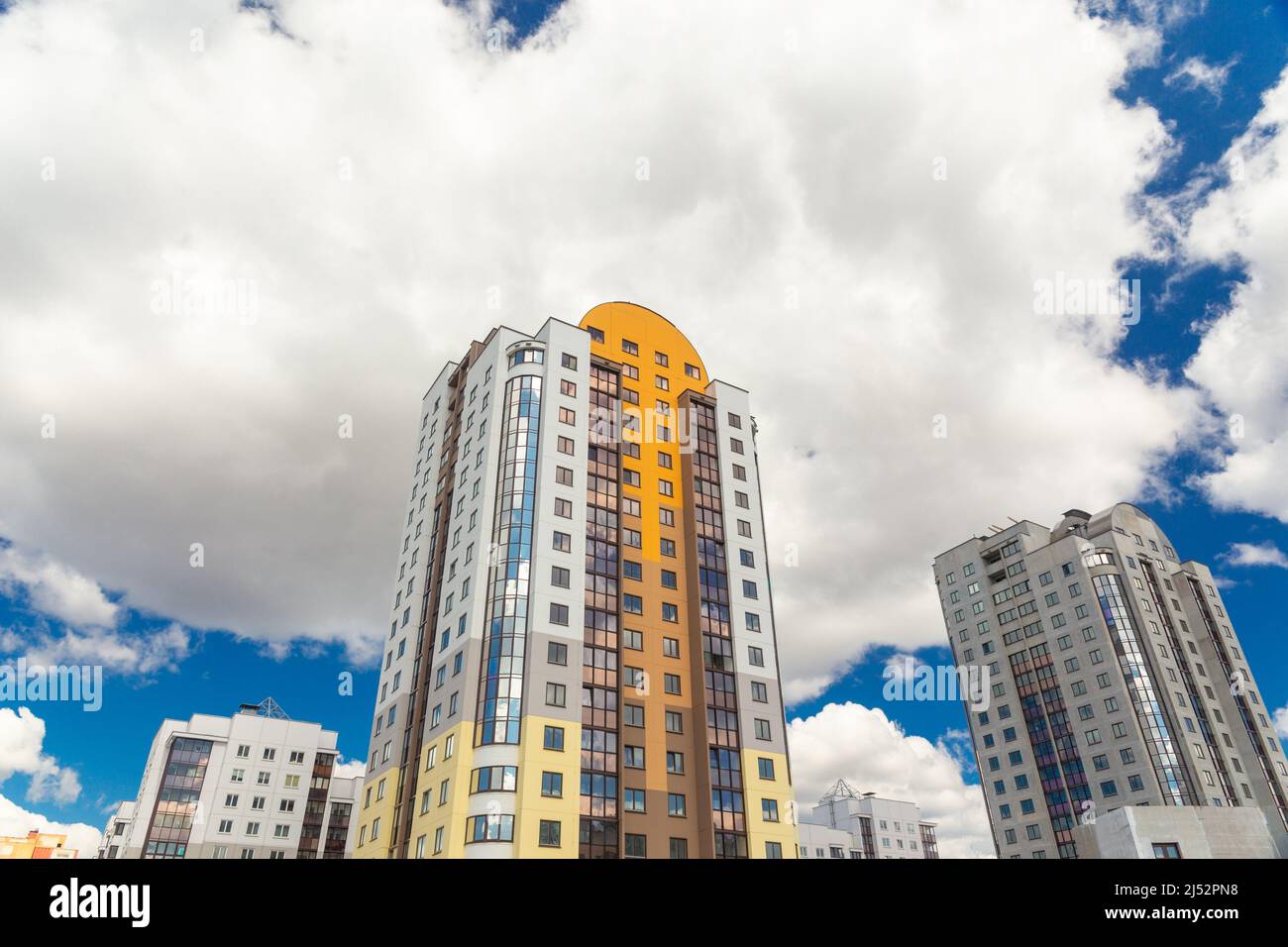 White clouds over colorful buildings. Clouds passing over apartment ...