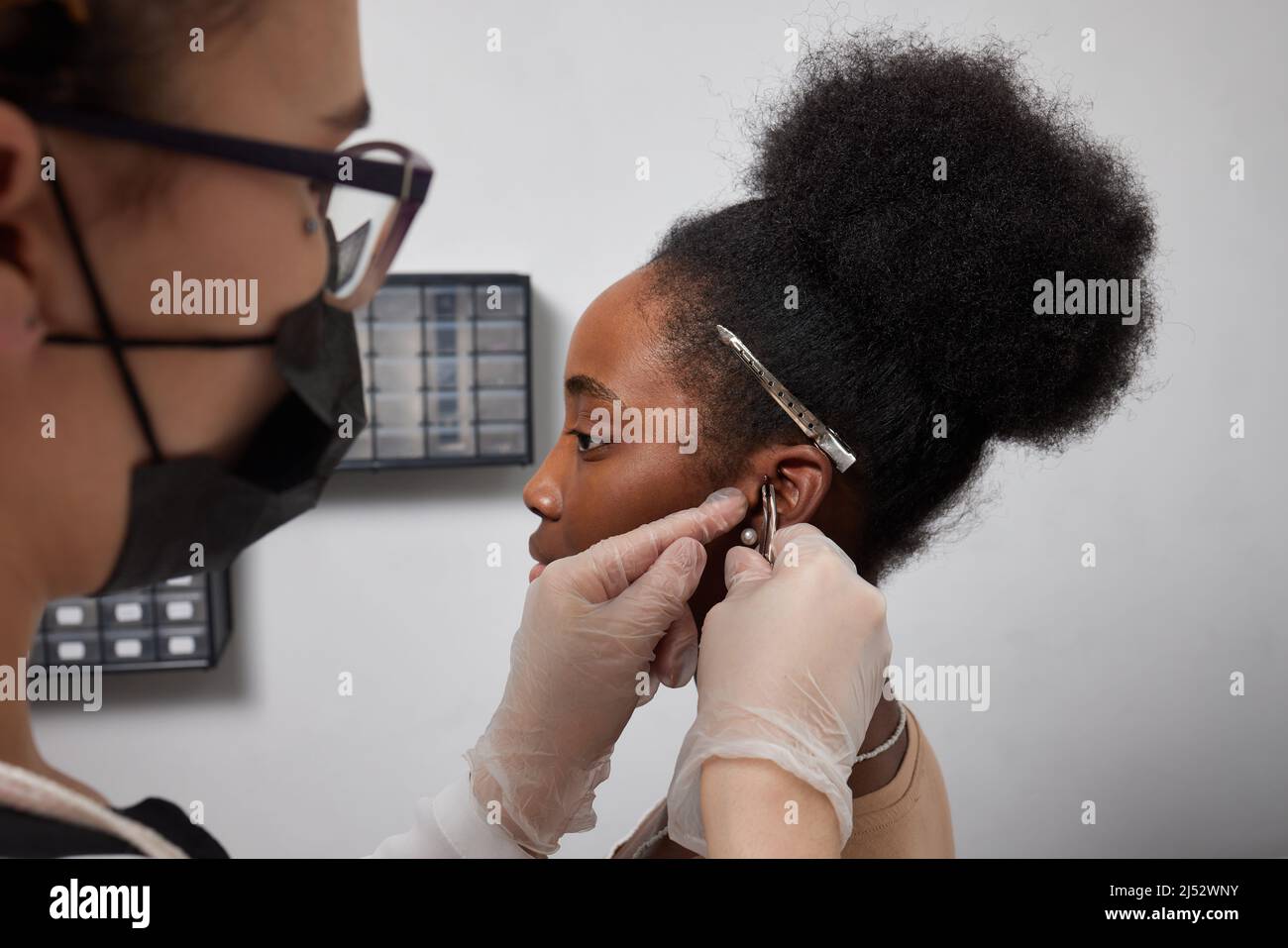Close up of woman's ear with pierced on her ear for treatment of the ...