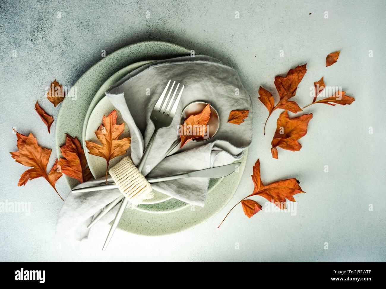 Overhead view of an autumnal place setting with dried autumn leaves ...