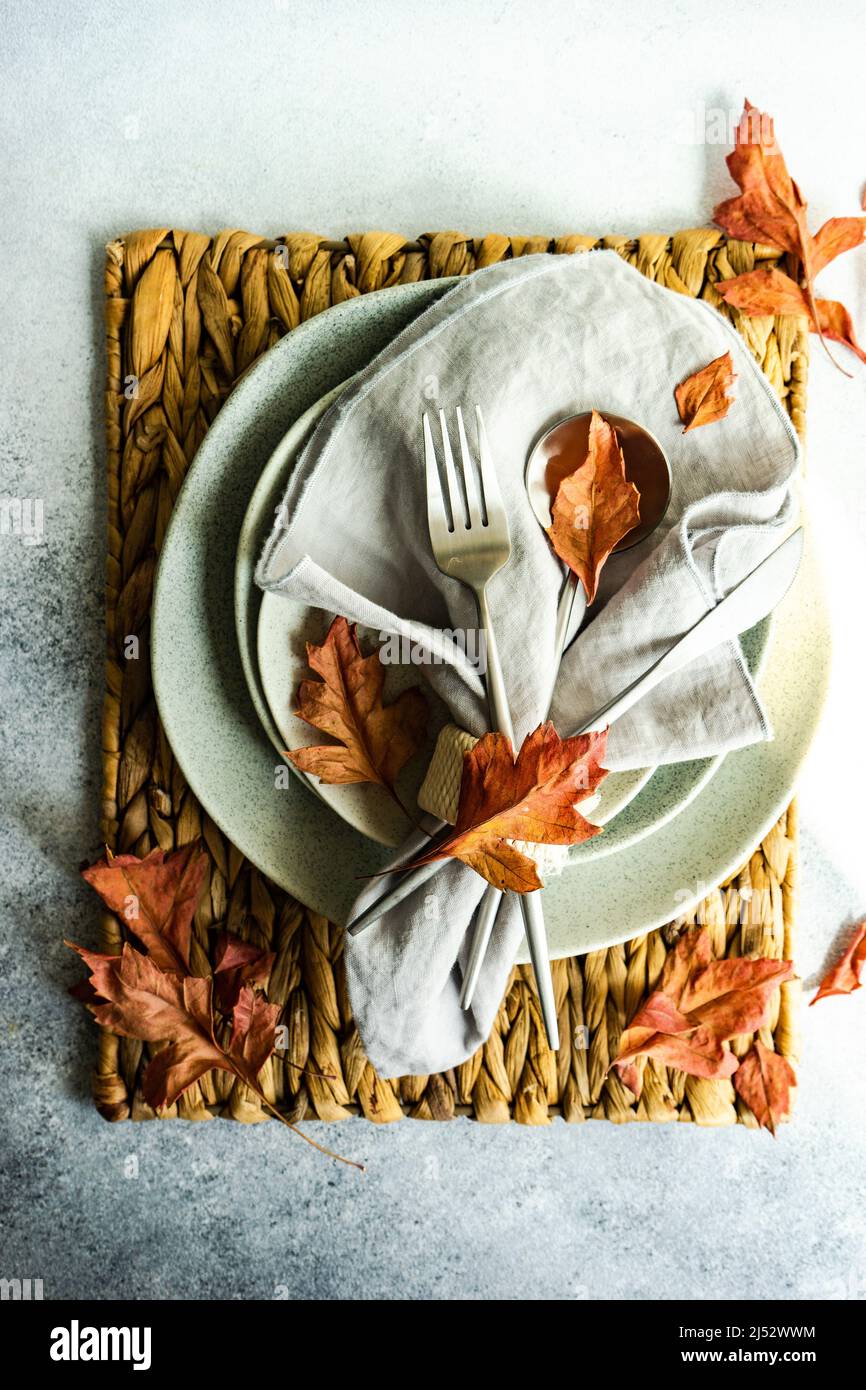 Overhead view of an autumnal place setting with dried autumn leaves ...