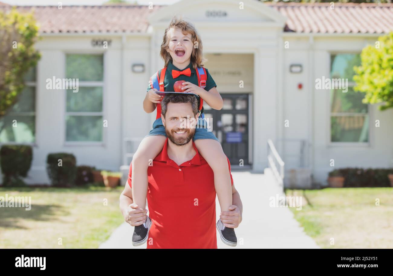 American father and son walking trough school park. Man and excited ...