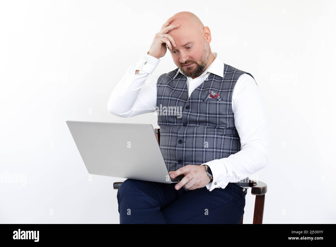 Portrait of bemused middle-aged man in grey checkered vest, blue jeans ...
