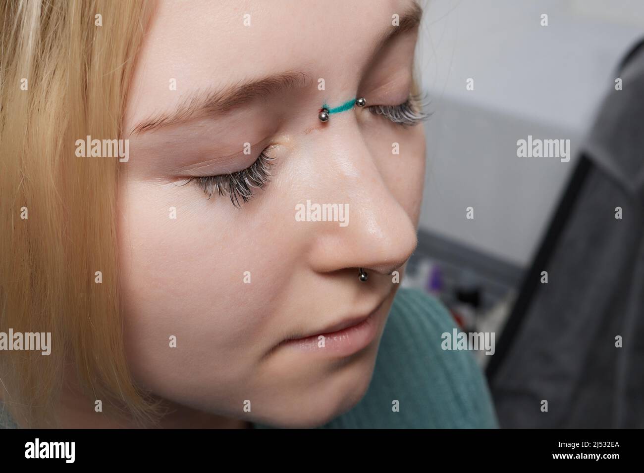 Nose Bridge Piercing Professional holding the jewel of piercing day ...