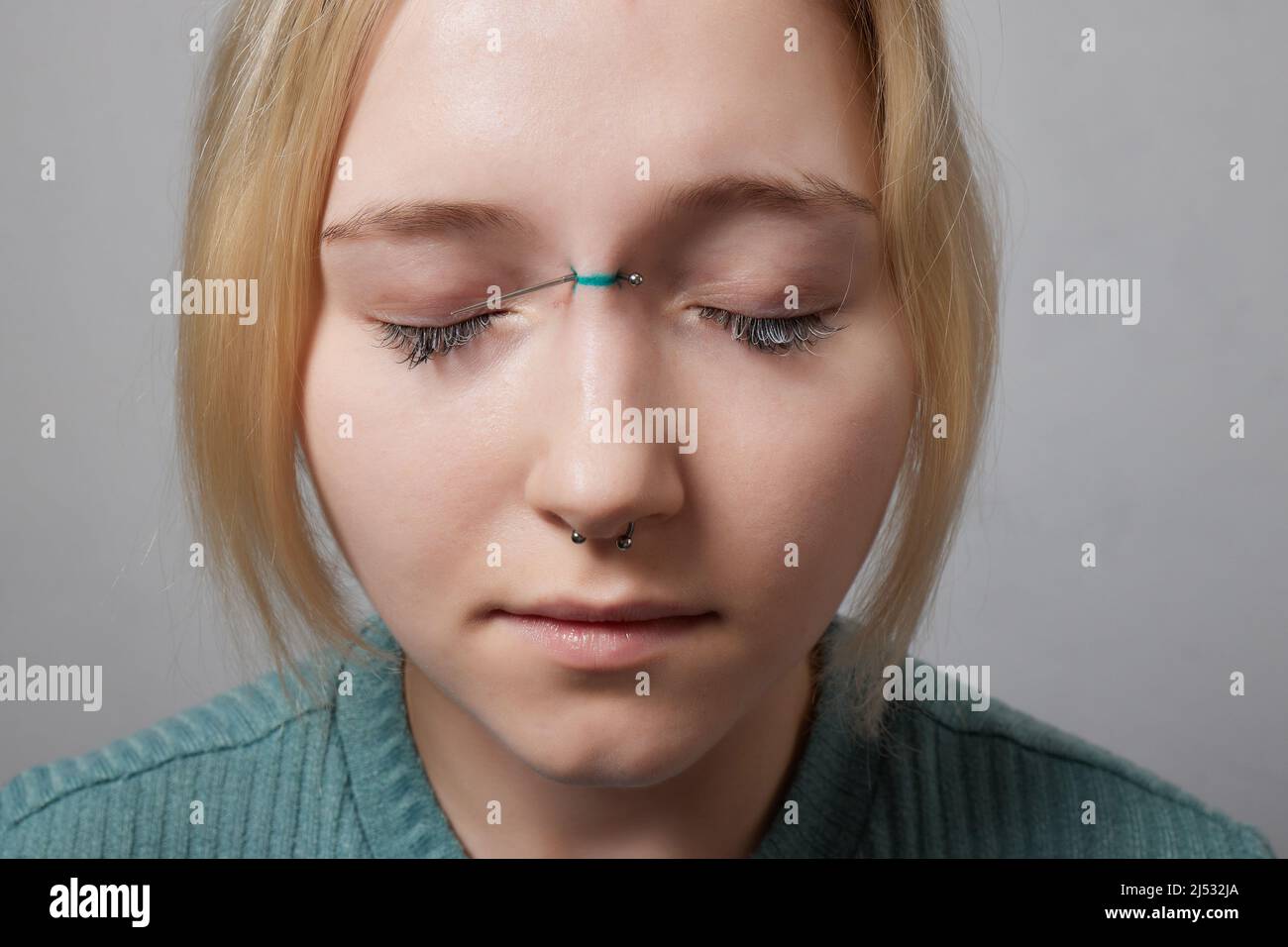 Nose Bridge Piercing Professional holding the jewel of piercing day ...