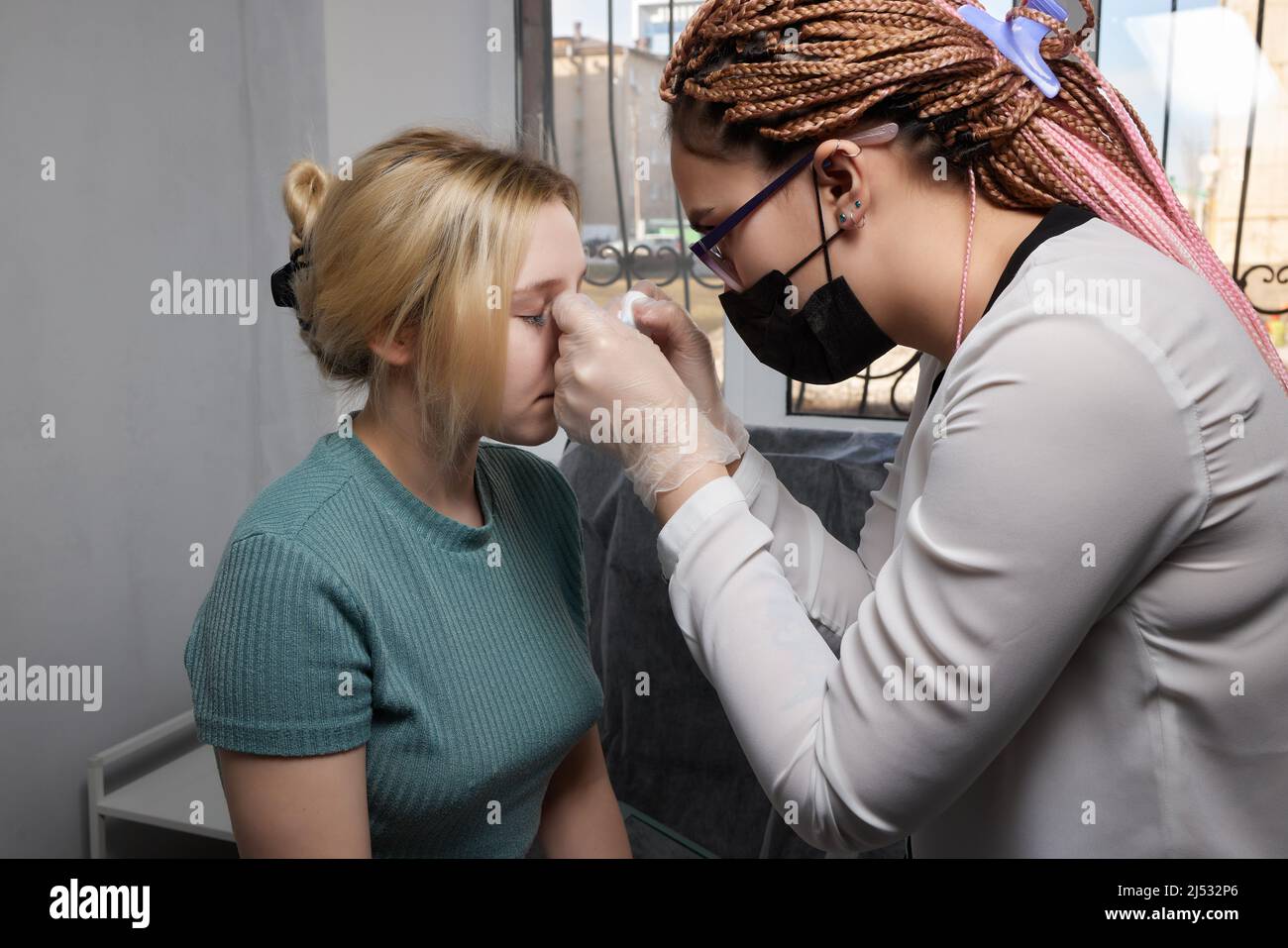 Nose Bridge Piercing Professional holding the jewel of piercing day ...