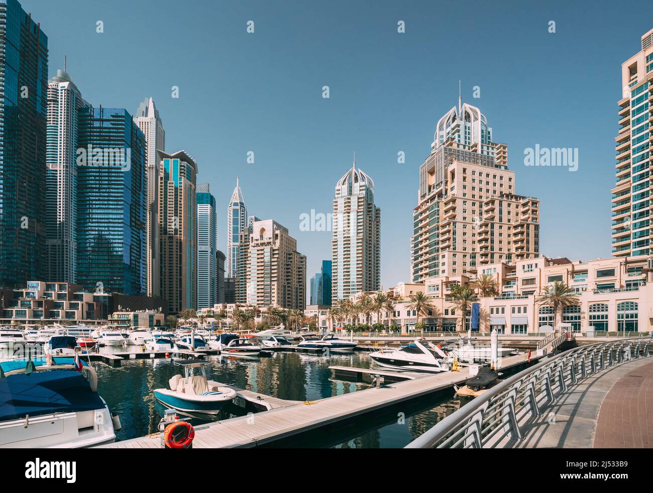 Yachts are moored at city pier, jetty in Dubai Marina. Cityscape ...
