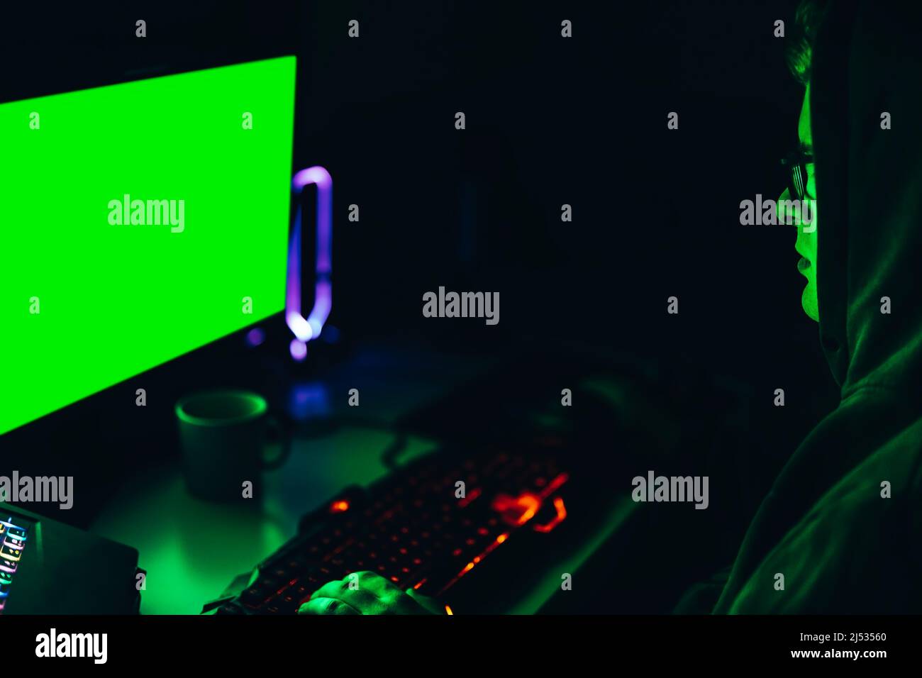 Dangerous hooded hacker using computer for cyber war between countries ...