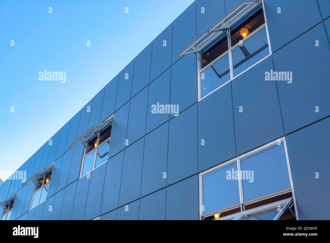 Low angle view of a building with black exterior wall cladding and ...