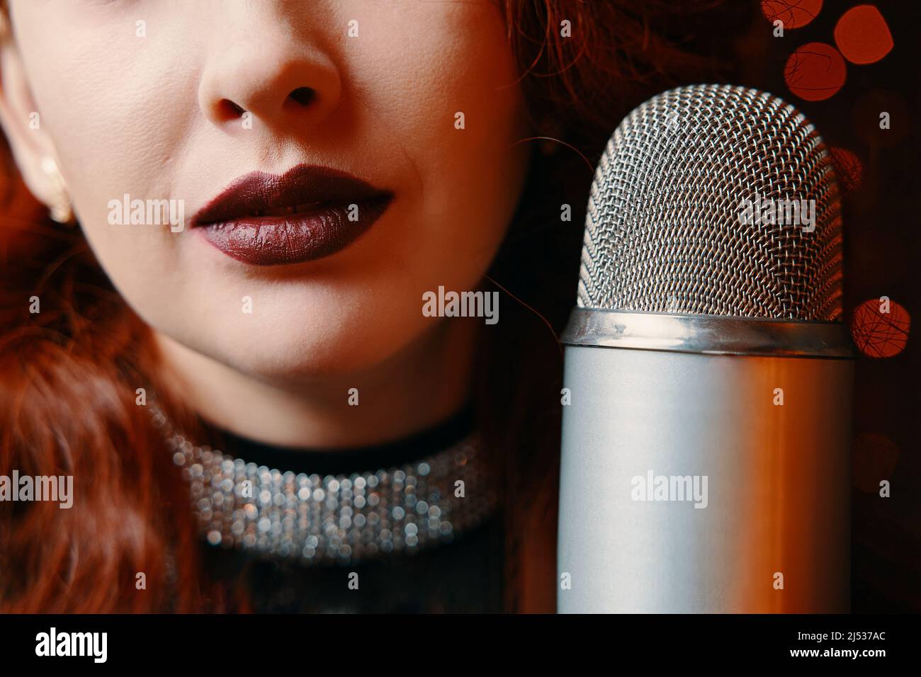 Female singer with disco mic on bokeh light background Stock Photo - Alamy