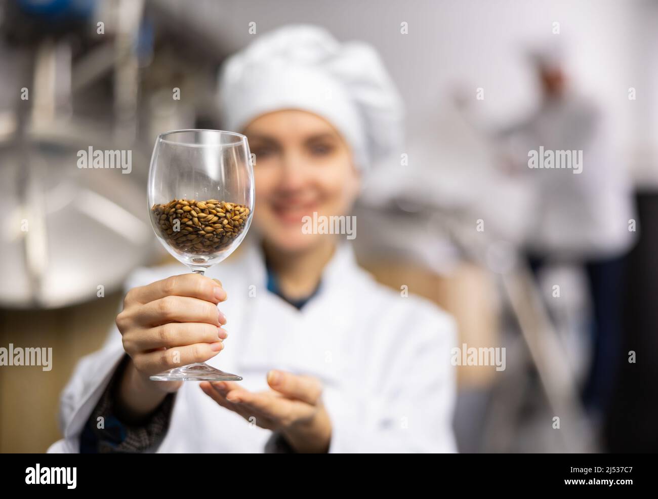 Female brewmaster holding glass of malt Stock Photo - Alamy