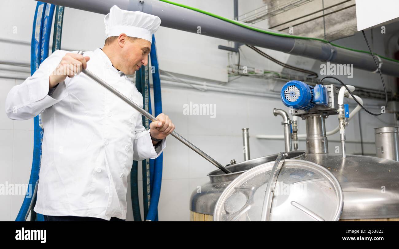 Brewer is controls the brewing process near reservoir with beer Stock ...