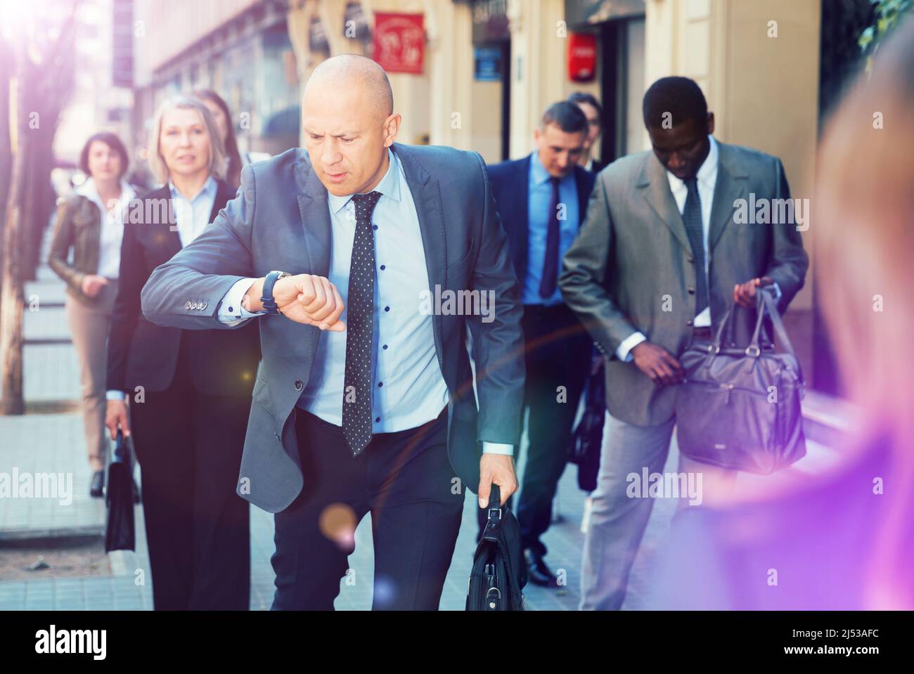 Stressed businessman checking time and running Stock Photo - Alamy