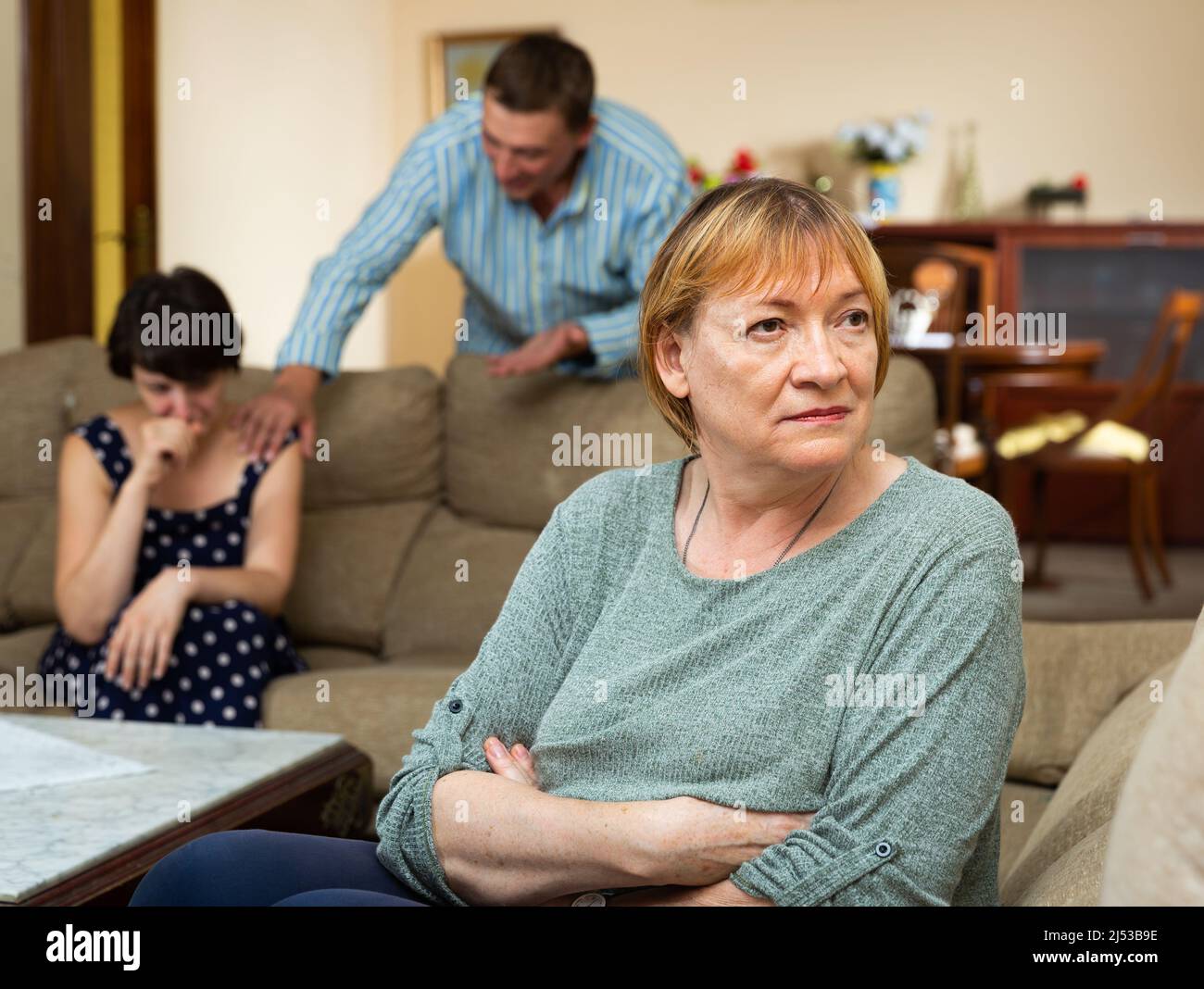 Upset elderly woman with arguing couple Stock Photo - Alamy