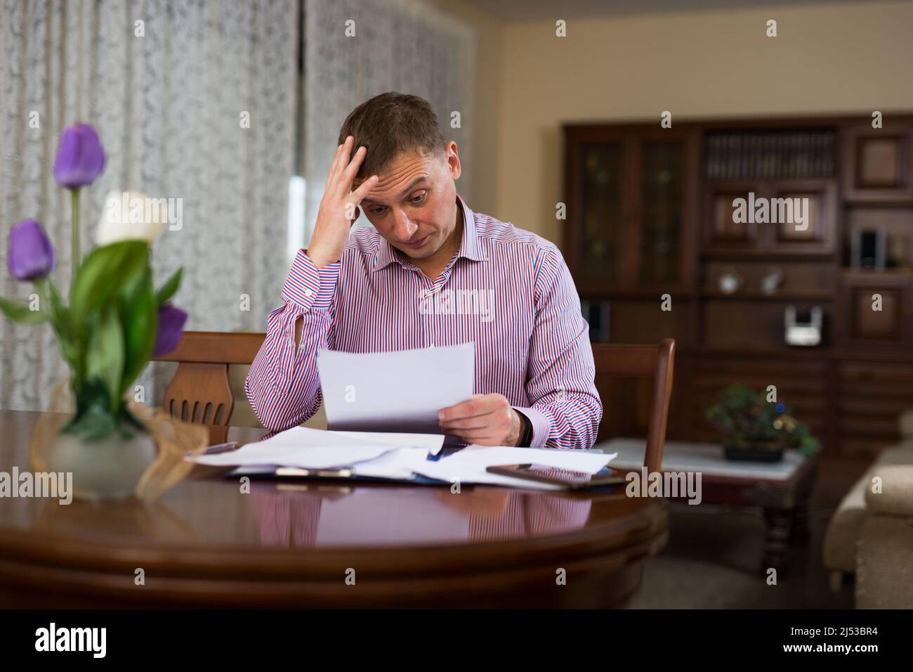 Concentrated man filling out papers Stock Photo - Alamy