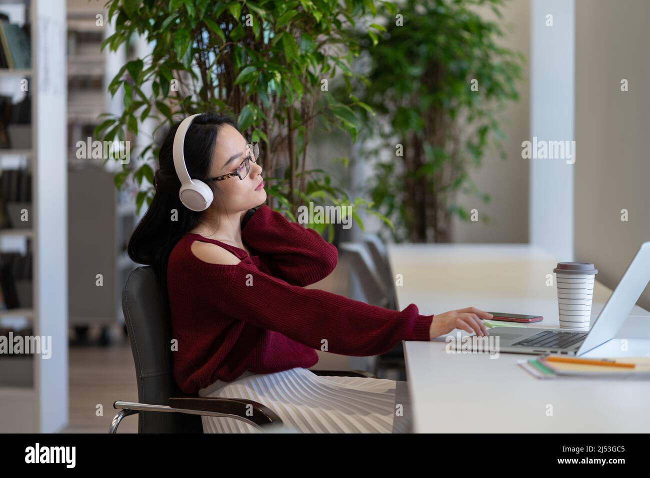 Overworked student woman touch painful neck exhausted work in library ...
