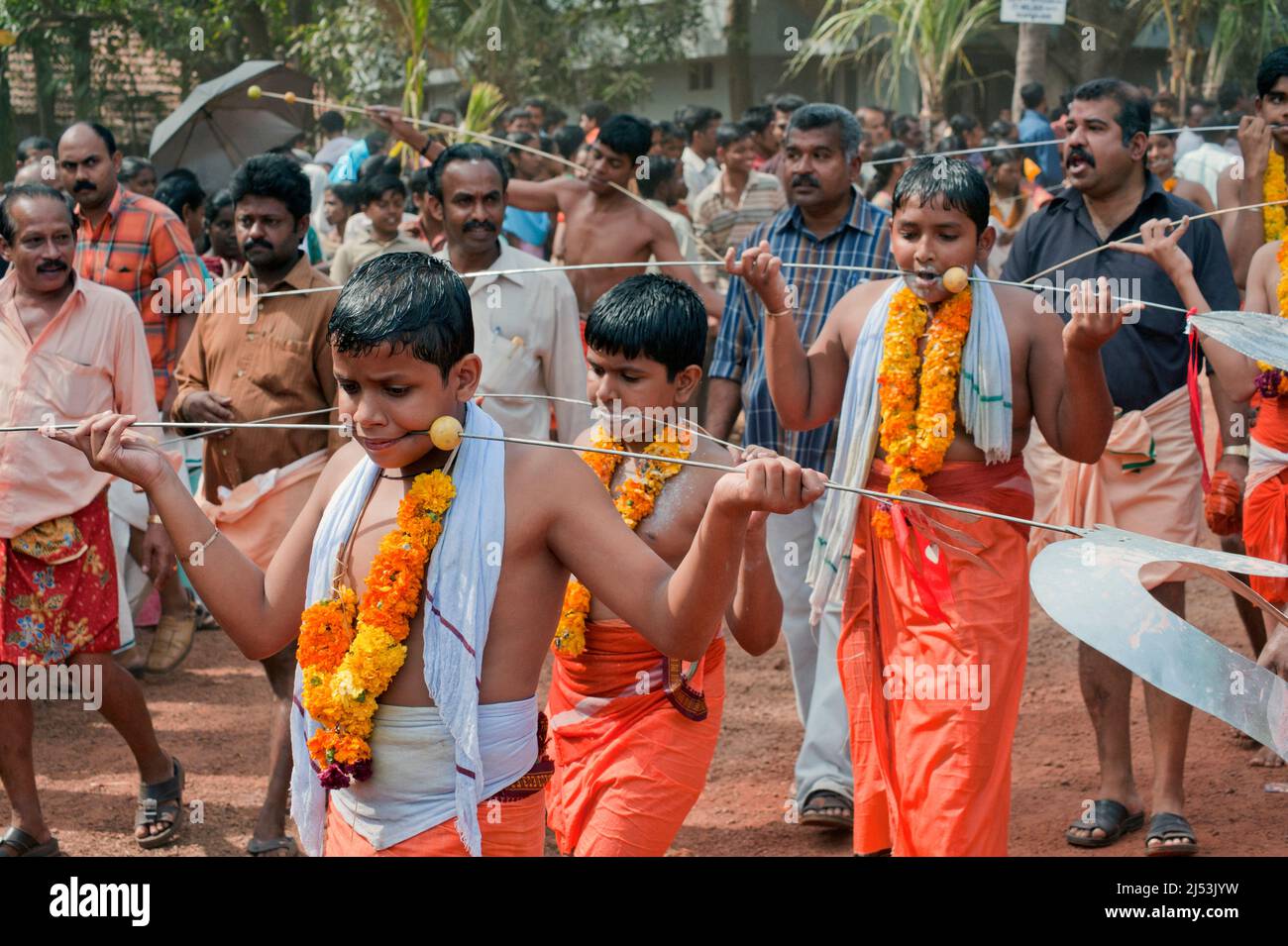 Young boys piercing spike through cheeks discharging vow in Thaipusam ...