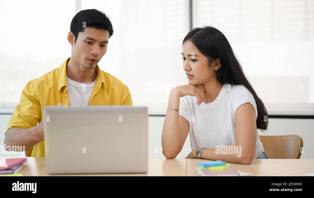 Smart Asian male software engineer fixing the online database problems ...