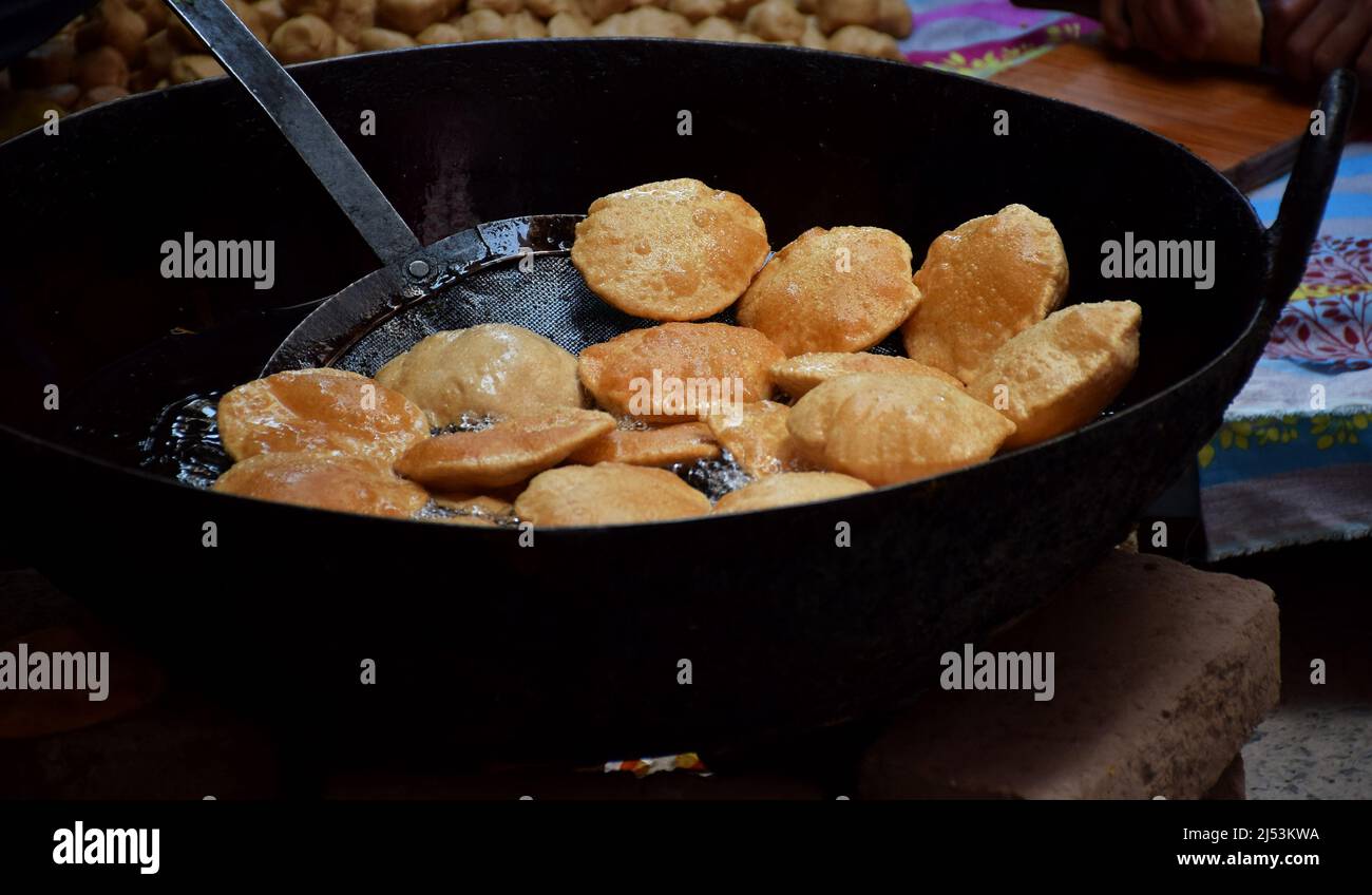 Indian Poori making in progress. Puri is a fried flat bread which is a ...
