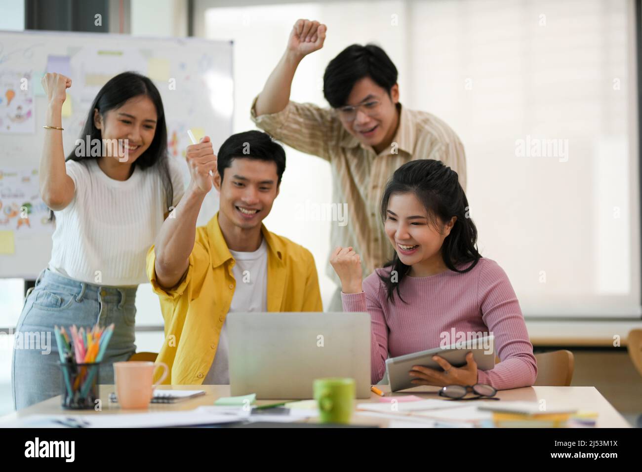 Successful Asian young startup group working and celebrating together ...