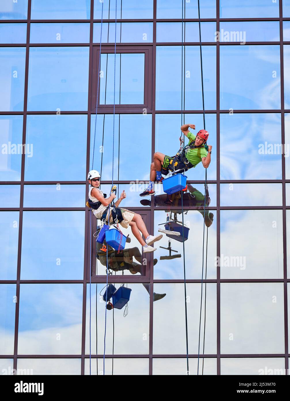 Industrial mountaineering workers professional cleaners washing glass ...