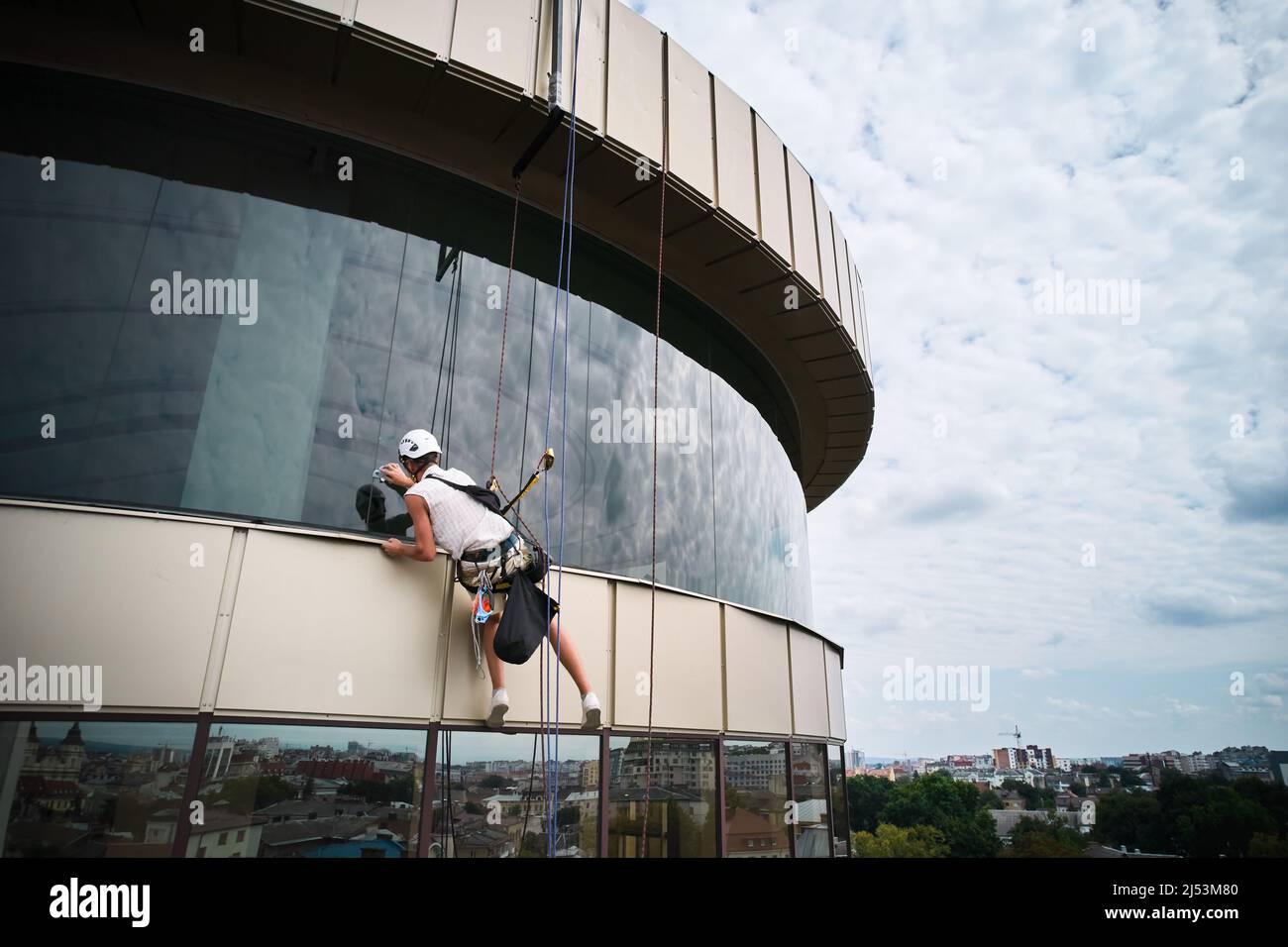 Industrial mountaineering worker professional cleaner hanging on ...