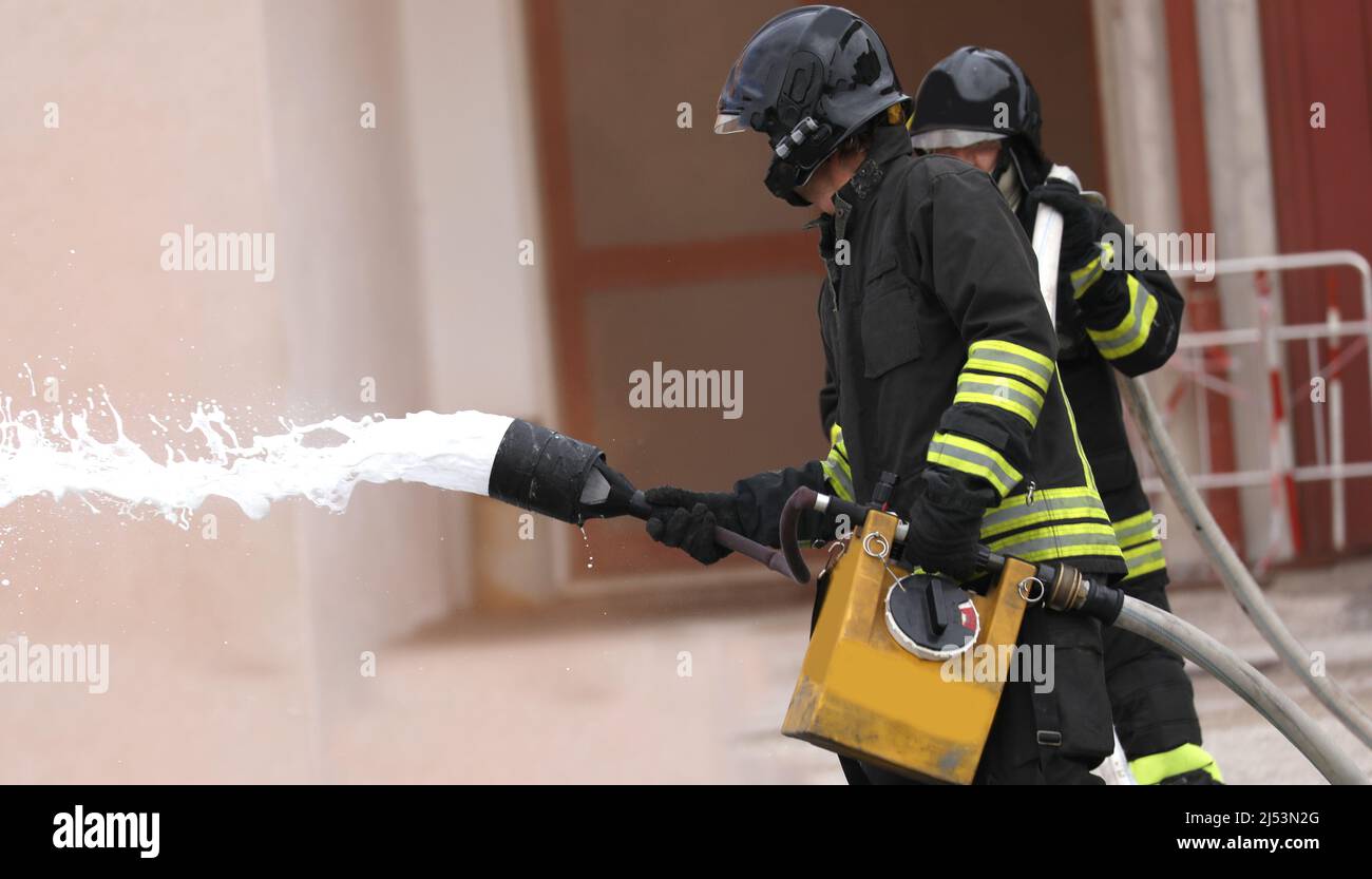 fire brigade team in action while extinguishing the fire after the car ...