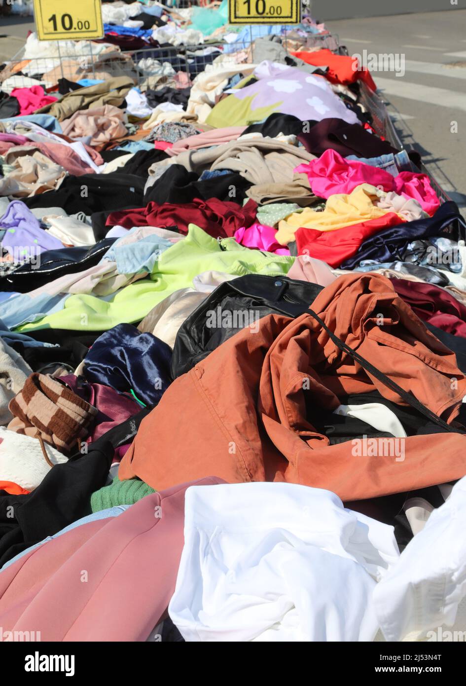 stall of colorful dresses for sale at the street market by day and the ...