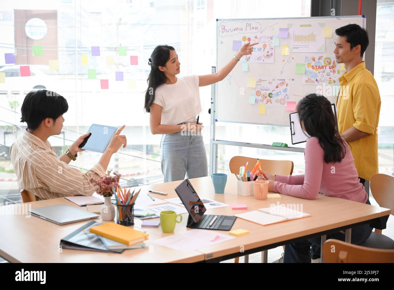 Attractive Asian businesswoman training and coaching their team in the ...