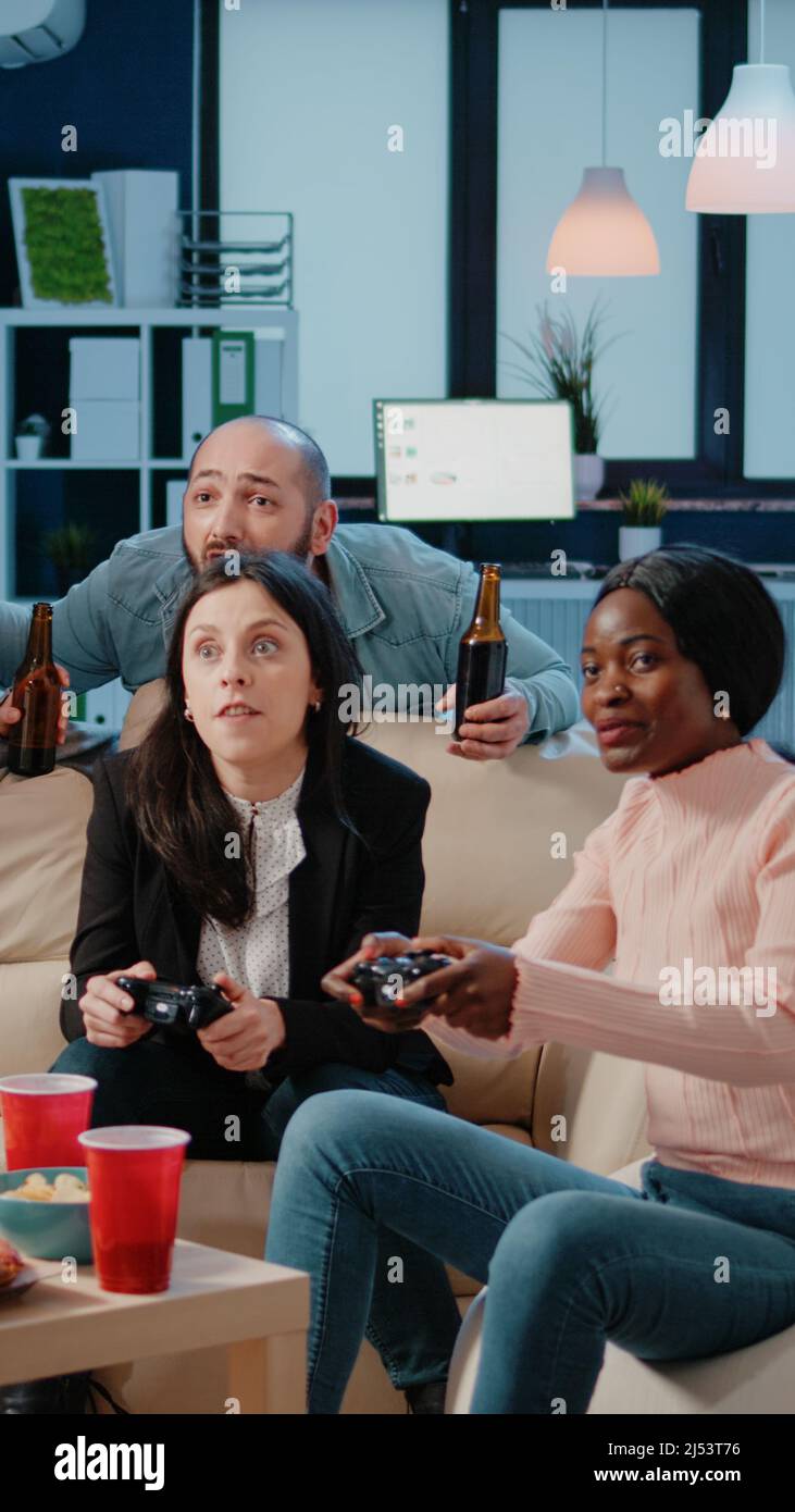 Colleagues playing video games on console with controller after work ...