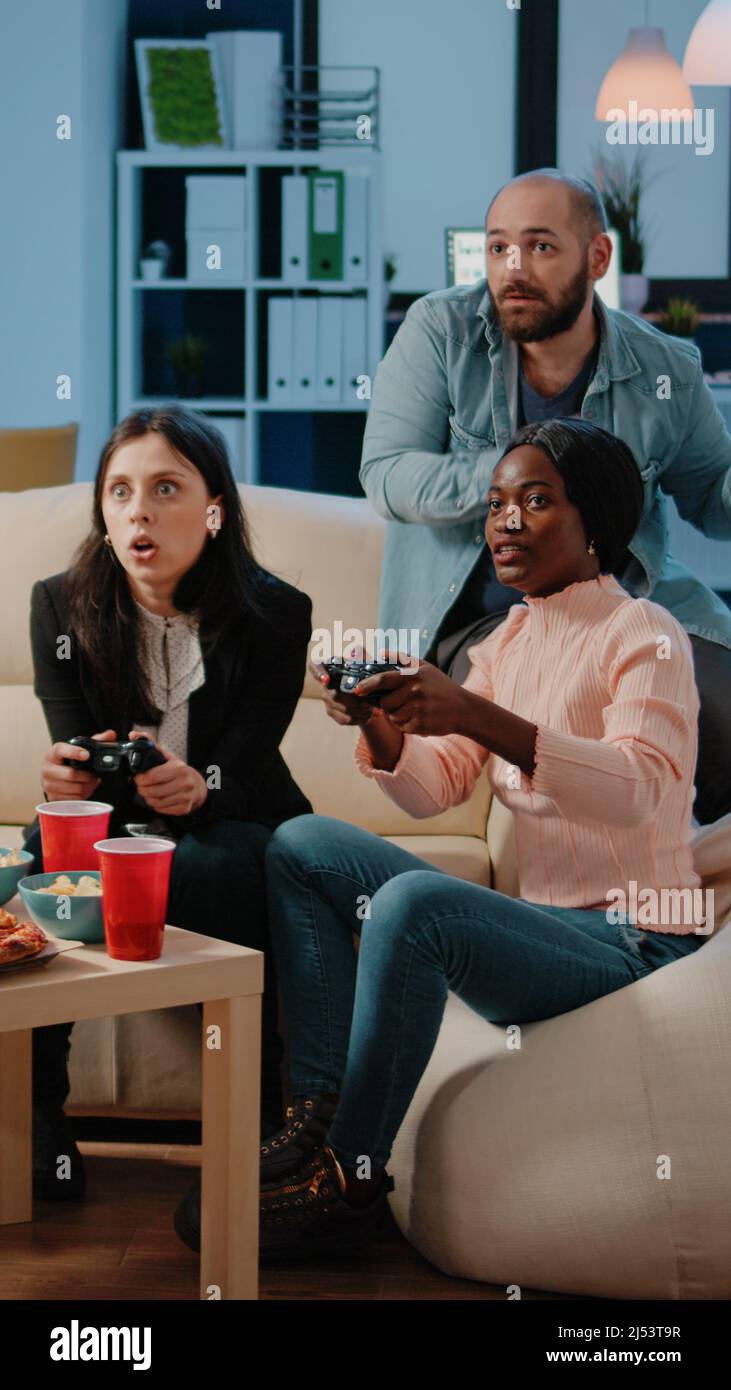 Happy colleagues playing video games on console television with ...