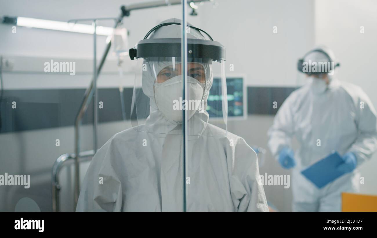 Portrait of medic wearing hazmat suit in lockdown zone at facility ...