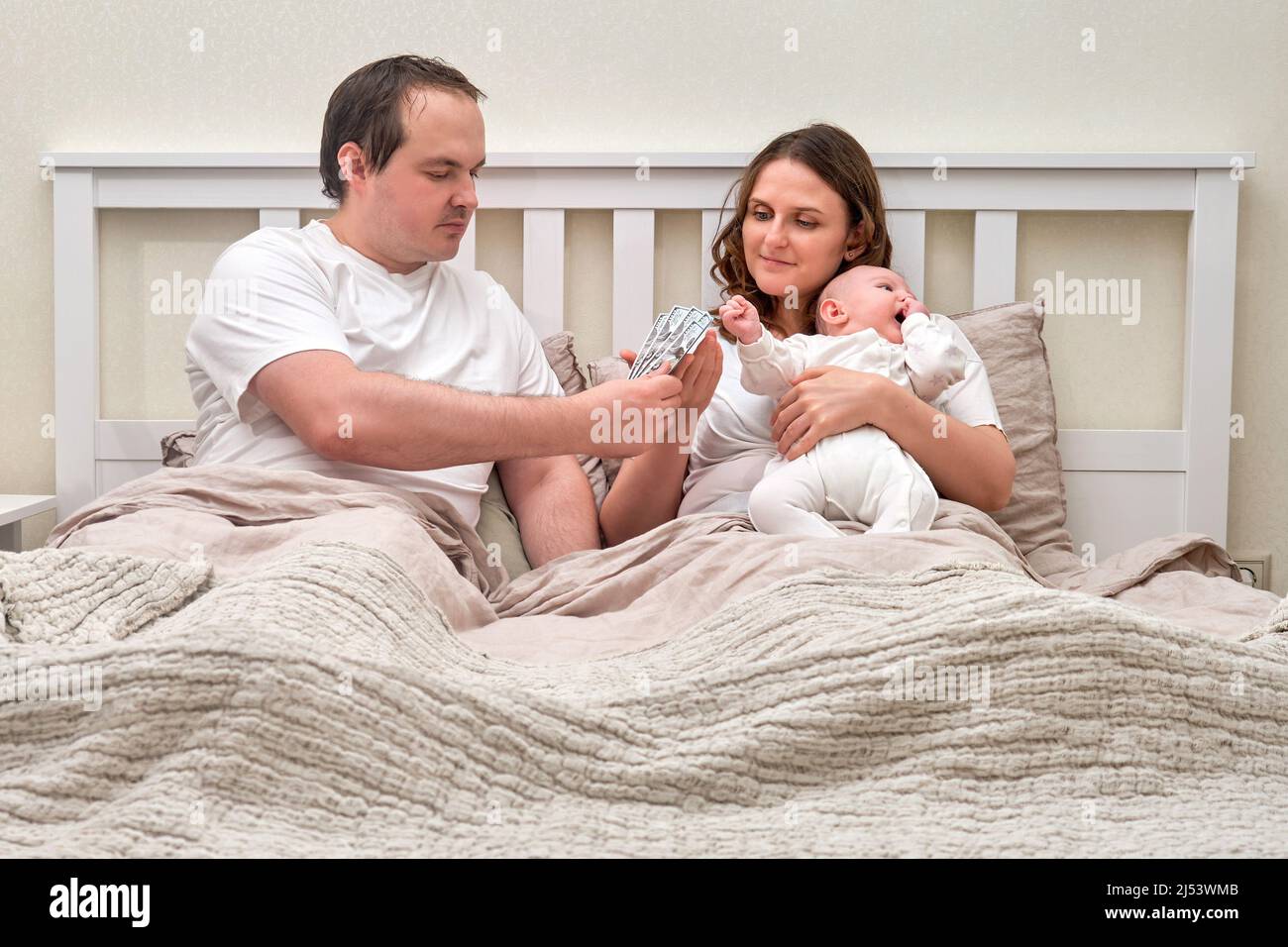 Mother and father with baby boy with money for upbringing, financial ...