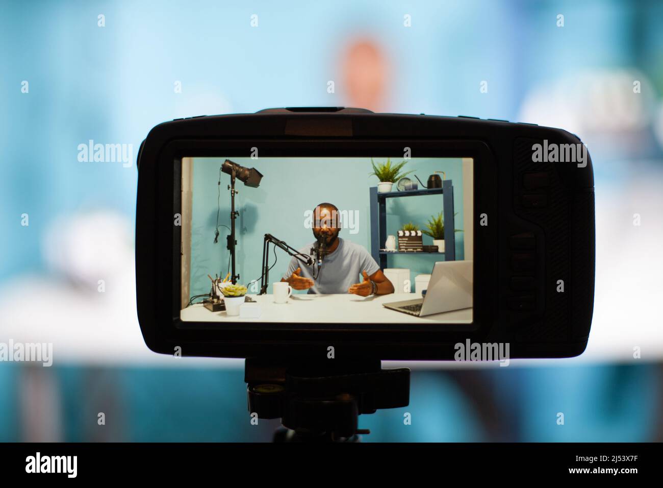 Selective focus on back screen of dslr filming influencer sitting at ...