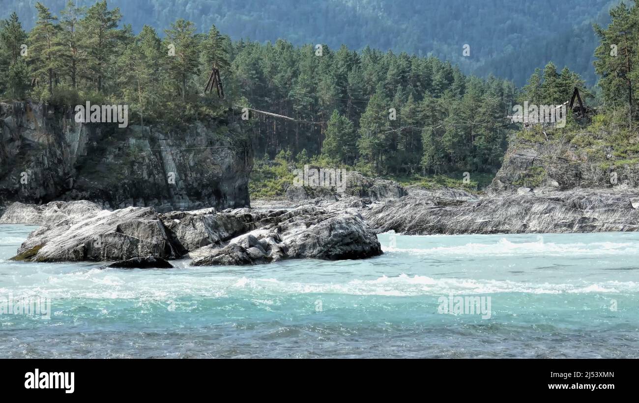 Wild mountain river. Fast water stream, hills and trees behind Stock ...